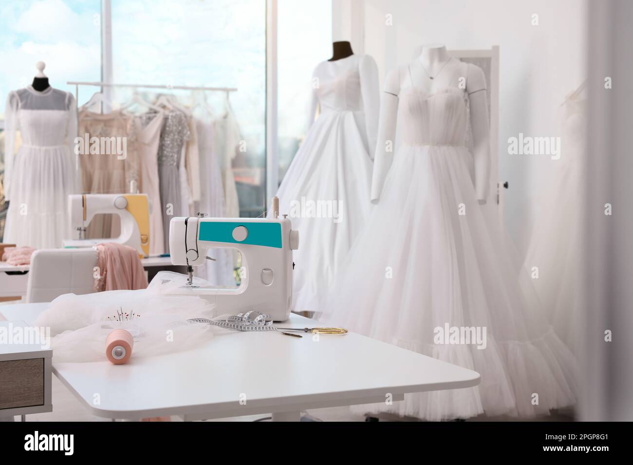 Dressmaking workshop interior with wedding dresses and equipment Stock ...