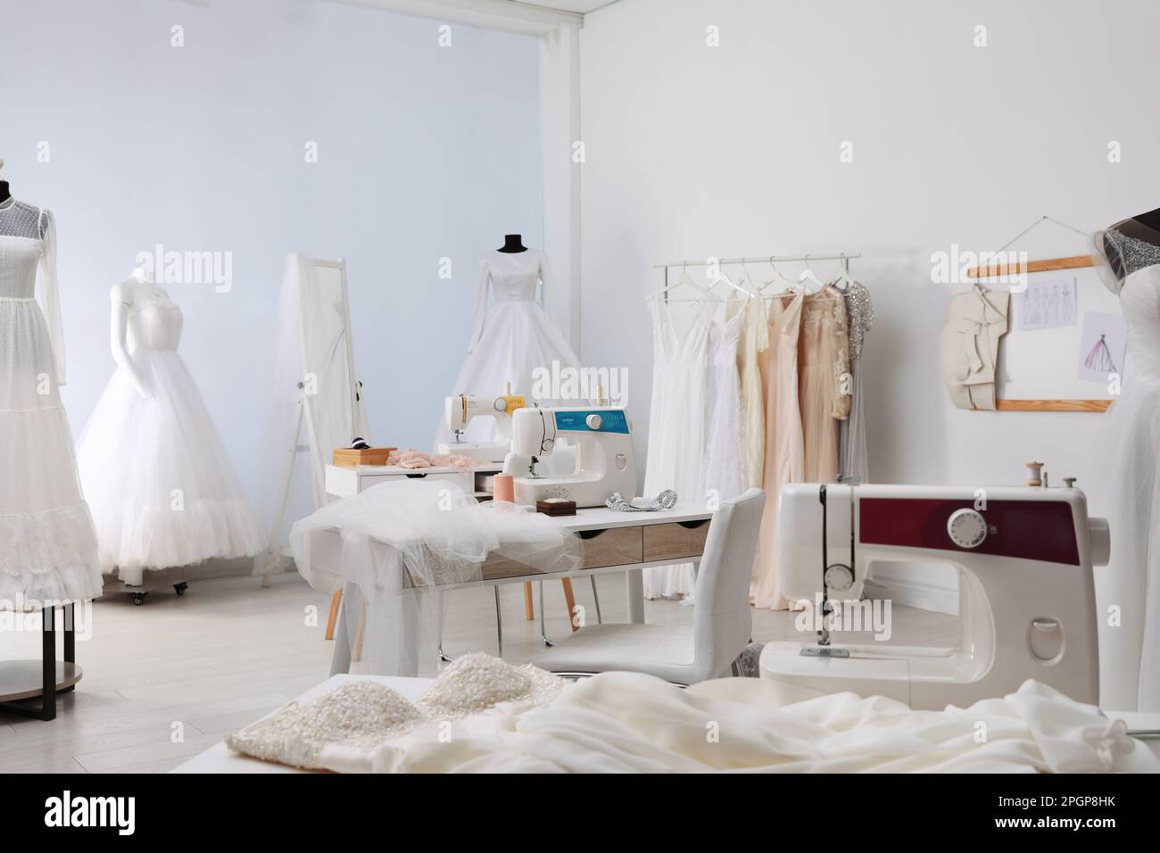 Dressmaking workshop interior with wedding dresses and equipment Stock ...