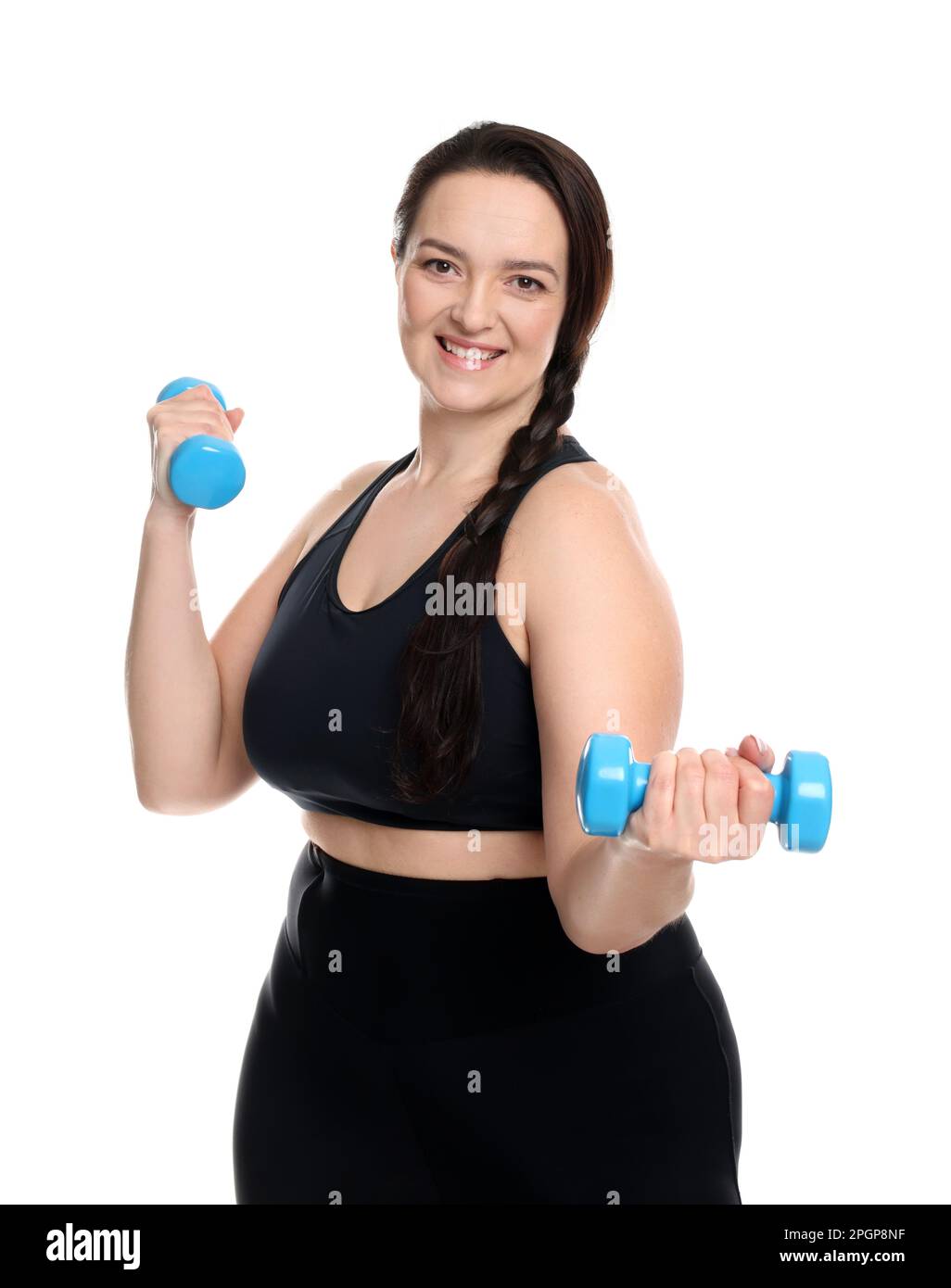 Happy overweight woman doing exercise with dumbbells on white ...