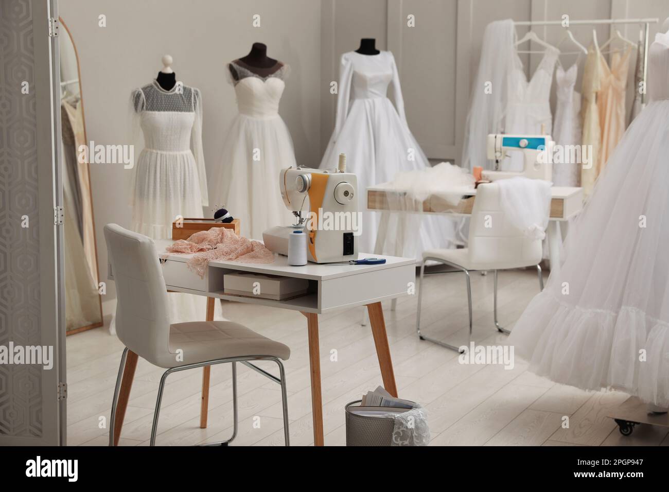 Dressmaking workshop interior with wedding dresses and equipment Stock ...