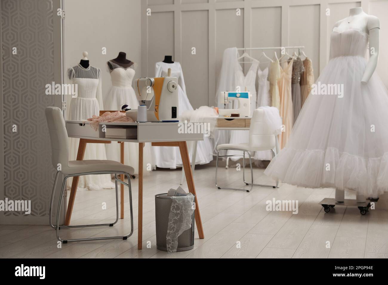 Dressmaking workshop interior with wedding dresses and equipment Stock ...