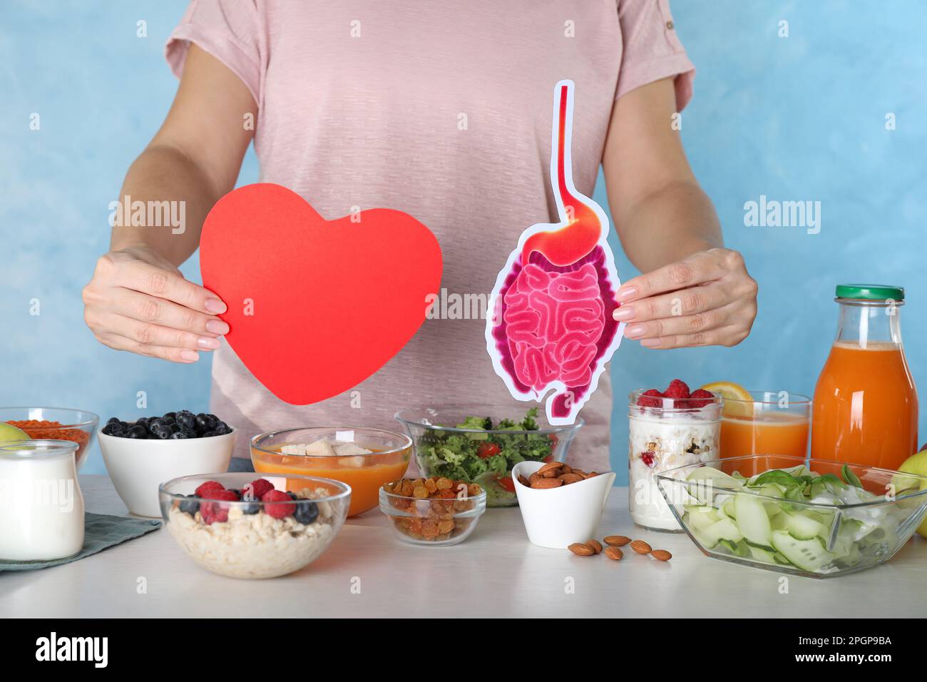 Woman holding paper intestine and heart near table with food, closeup ...