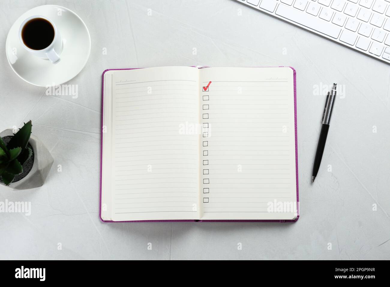 Notebook with checkboxes, cup of coffee and plant on white table, flat ...