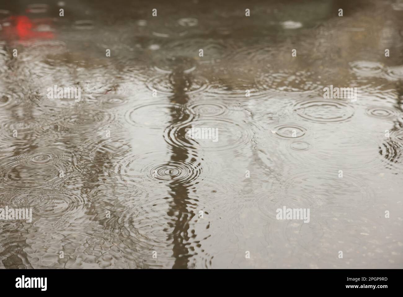 Rain drops falling down onto puddle outdoors Stock Photo - Alamy