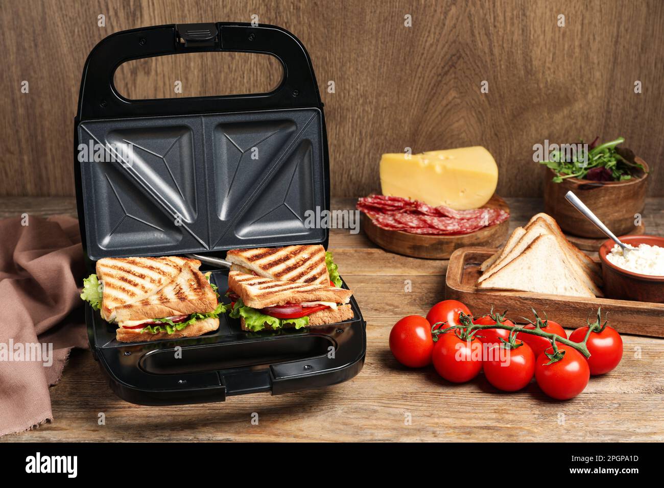 Modern grill maker with sandwiches and different products on wooden ...