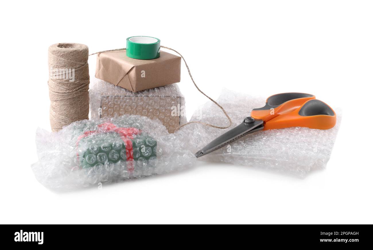 Cardboard boxes, bubble wrap, scissors and adhesive tape on white ...