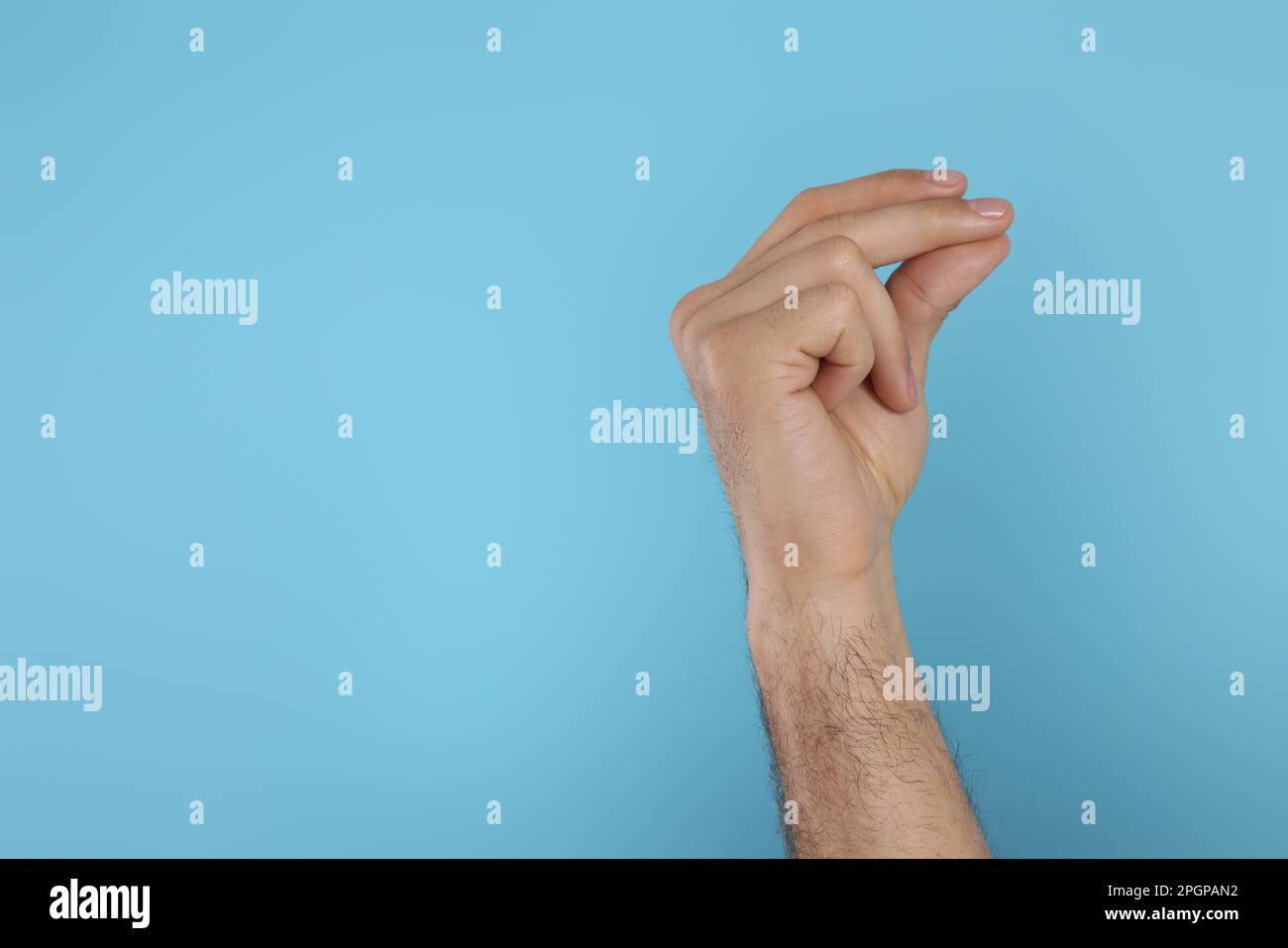 Man snapping fingers on light blue background, closeup of hand. Space ...
