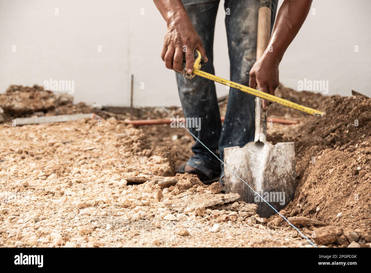 Man measuring and digging a hole in the ground with shovel Stock Photo ...