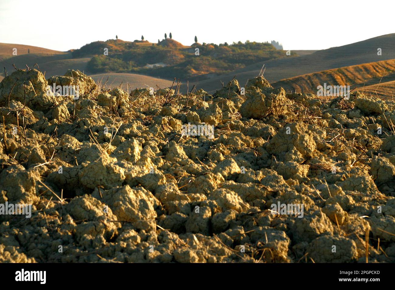 Clods of ploughed earth and Tuscanian landscape in the background ...