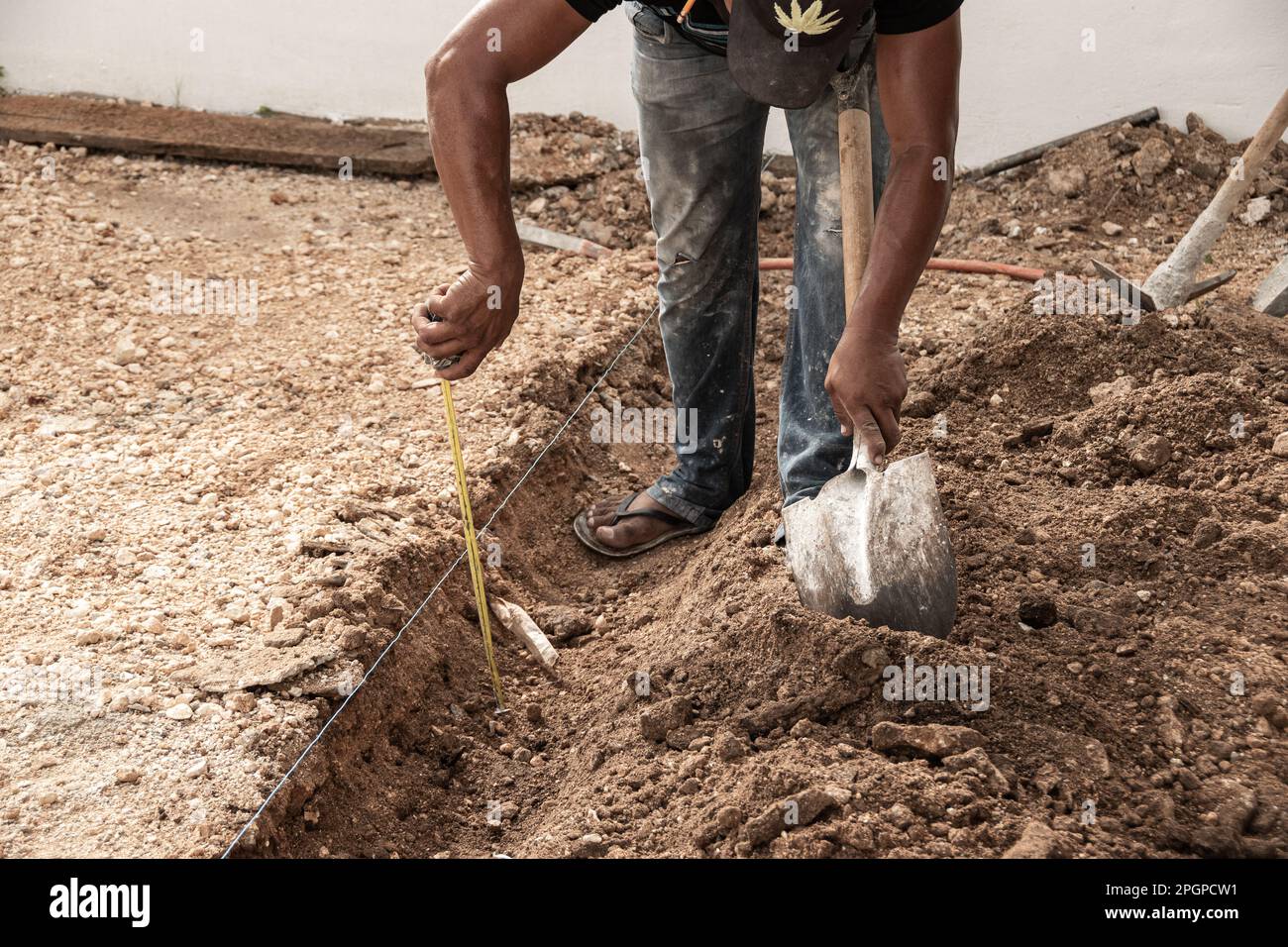Man measuring and digging a hole in the ground with shovel Stock Photo ...