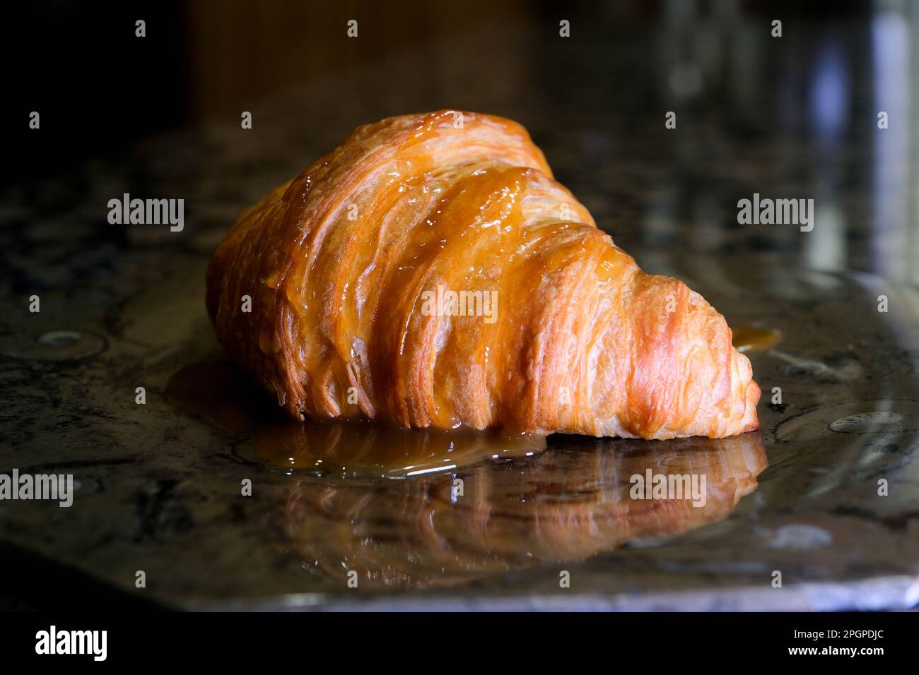 Fresh baked croissants. French croissants rotating on a black ...