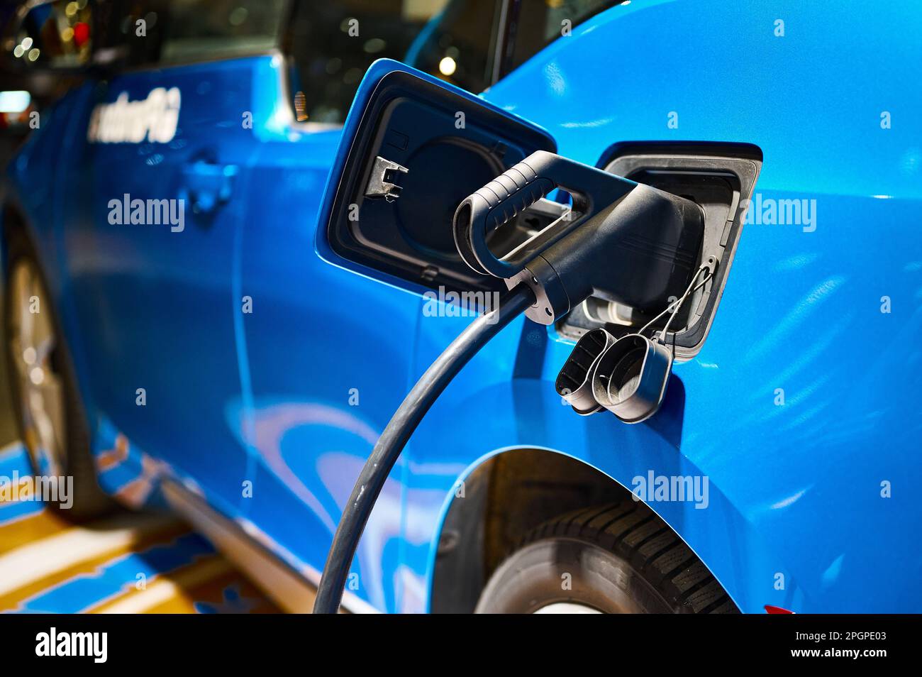 Charging electric blue automobile with plug at power station Stock ...