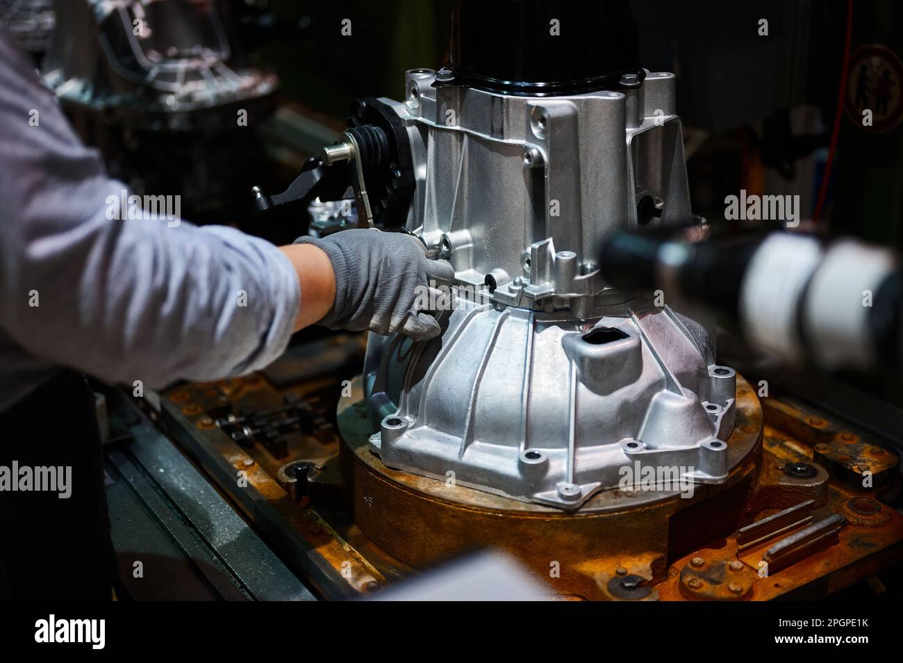 Worker connects car engine gearbox details on shop conveyor Stock Photo ...