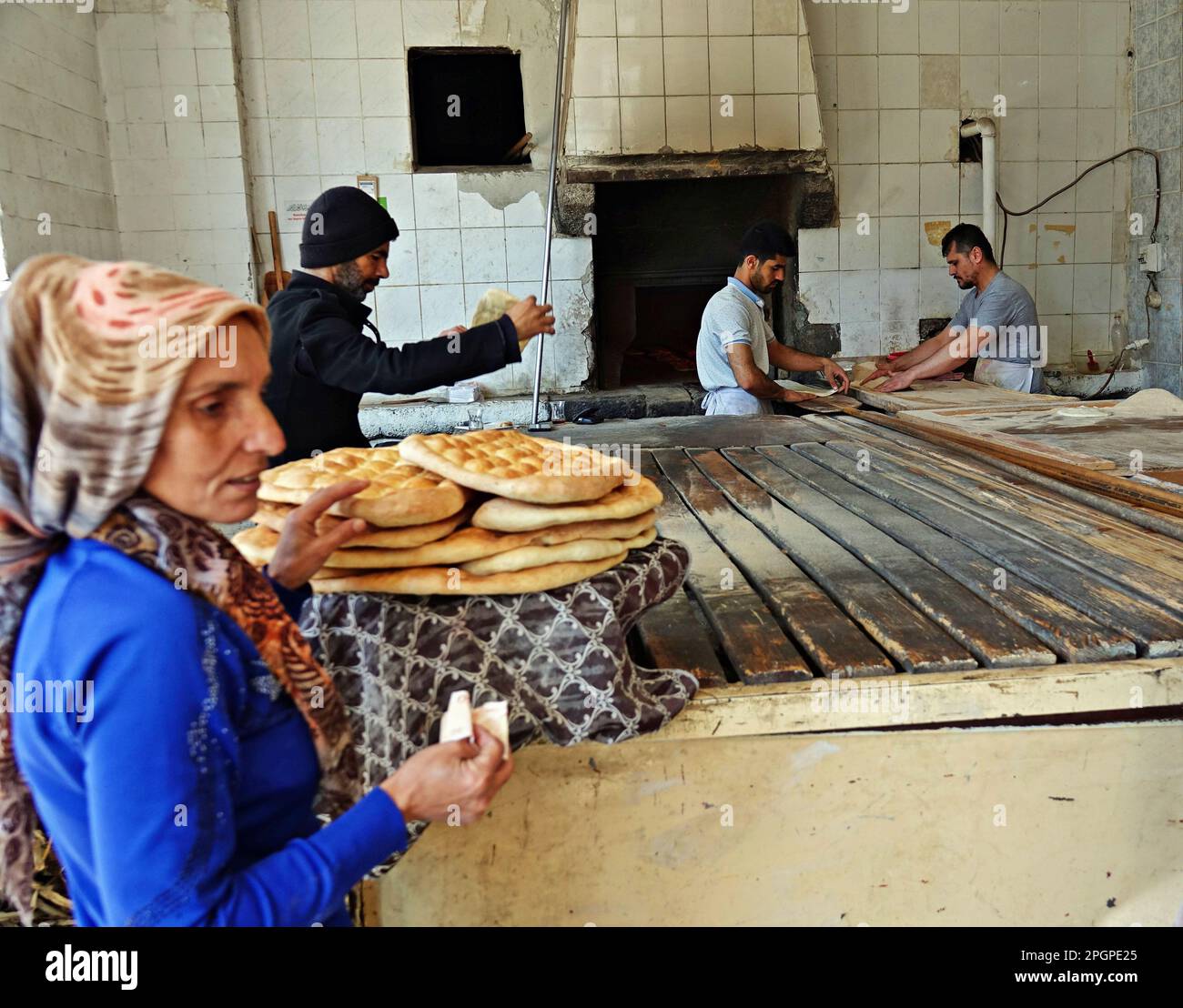A woman takes the dough she makes at home to the oven and bakes it is ...