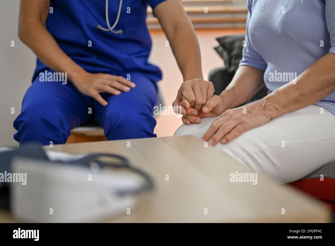 Cropped image of a kind doctor holding or touching a patient's hand to ...