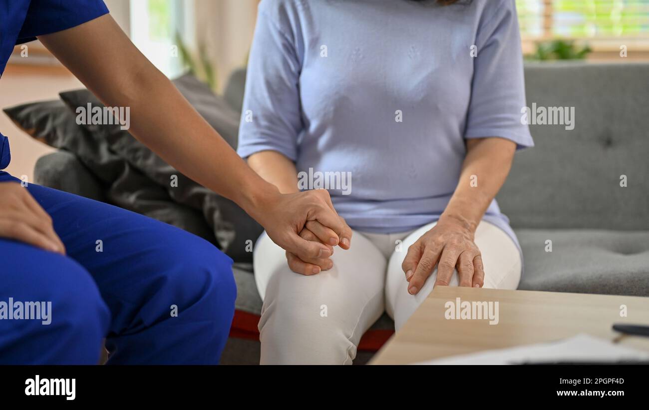 Close-up image of a kind doctor holding or touching a patient's hand to ...