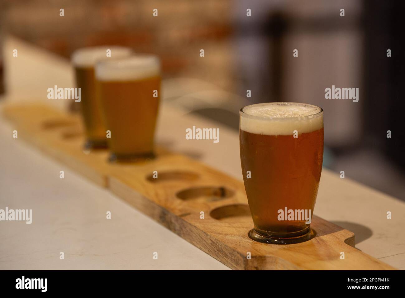 Three beers on a beer sample tray Stock Photo - Alamy