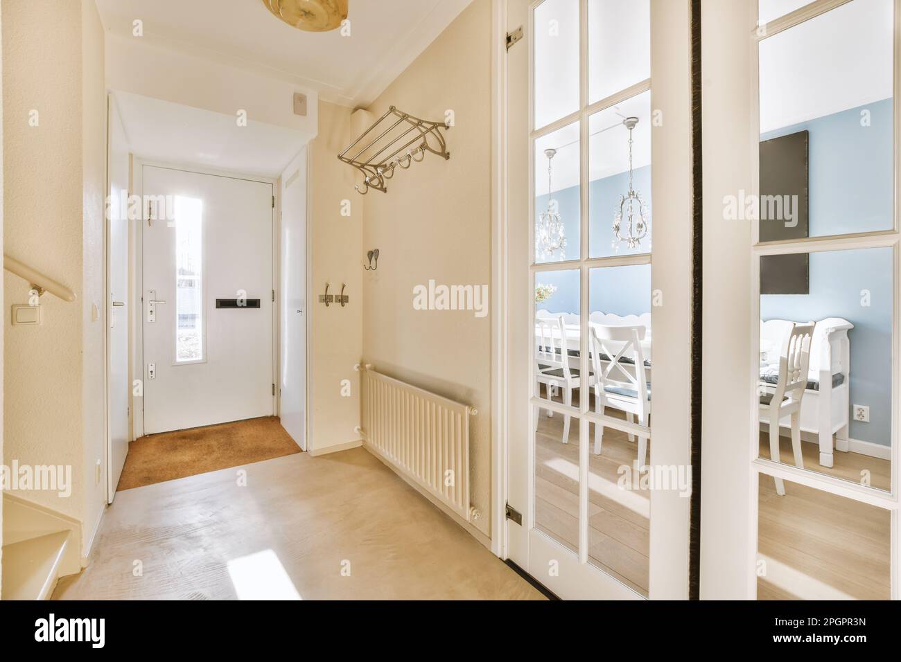 a hallway in a house with white furniture and large mirrors hanging on ...