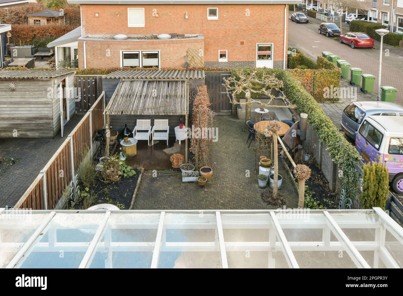 an outside area with cars parked in the street and houses on both sides ...