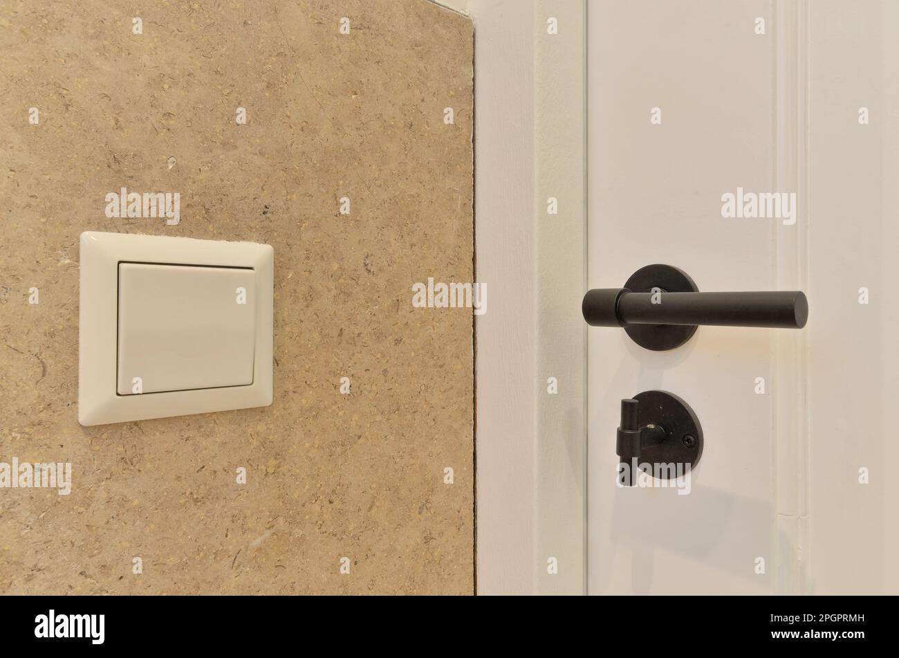 a white door with a black handle on it and an electrical outlet ...