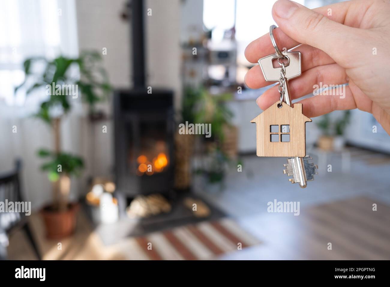 Key to house with keychain against background of fireplace stove with ...