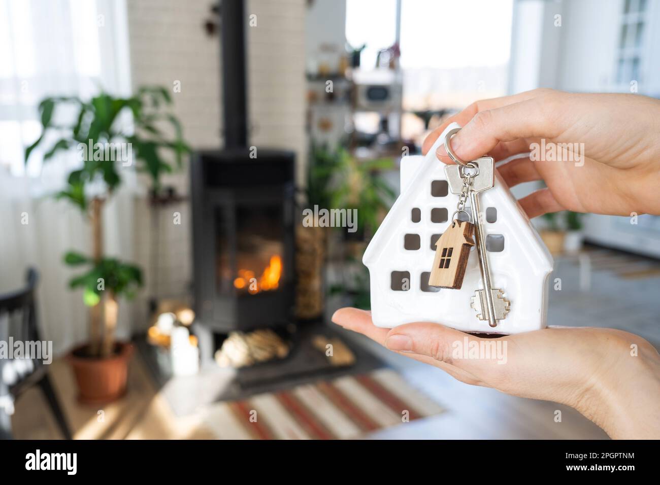 Key to house with keychain against background of fireplace stove with ...
