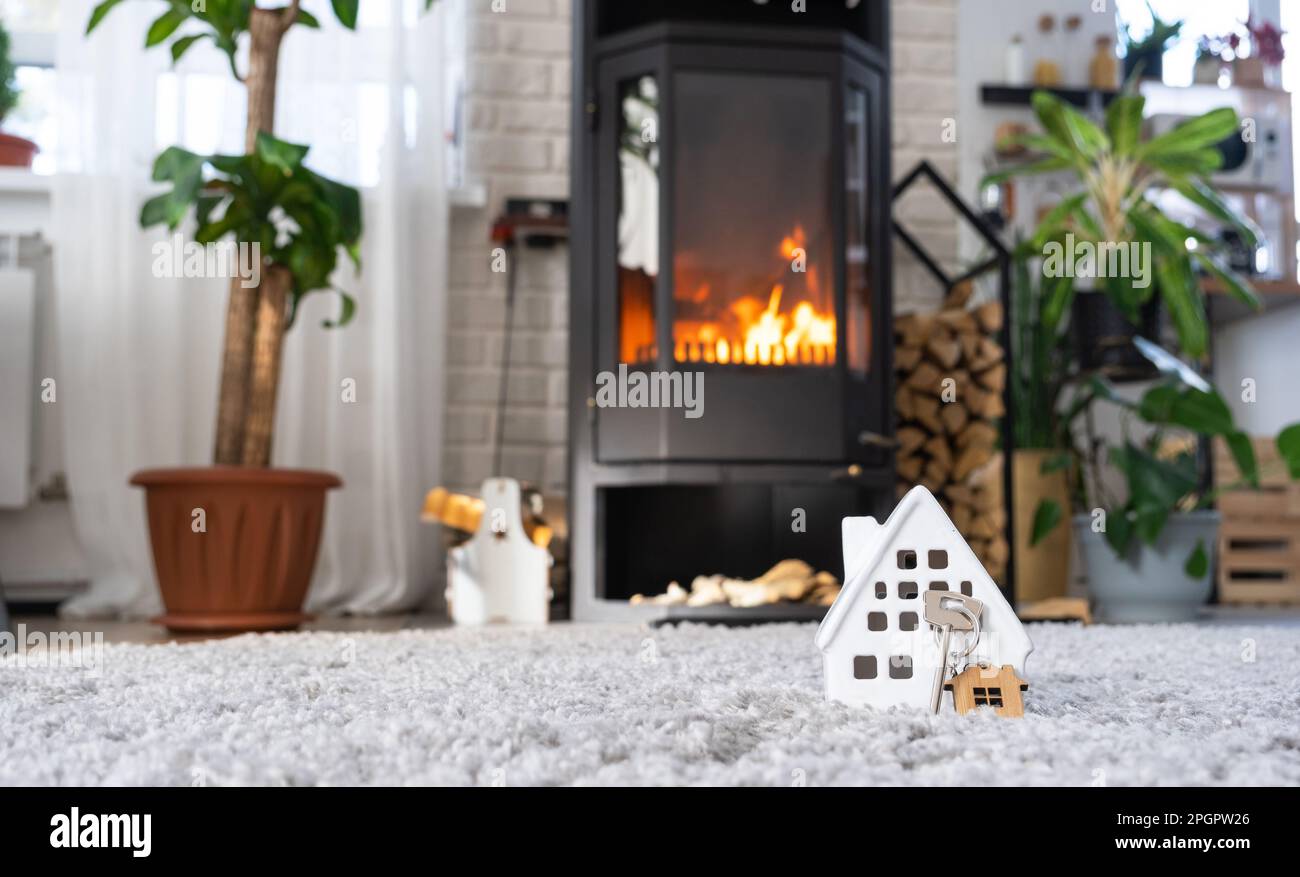 Key to house with keychain against background of fireplace stove with ...