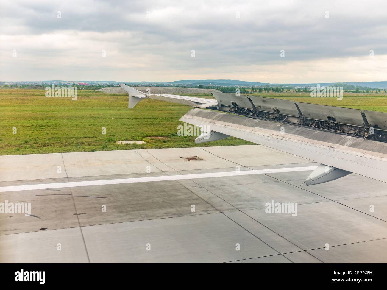 View of airplane wing, blue skies and green land during landing ...