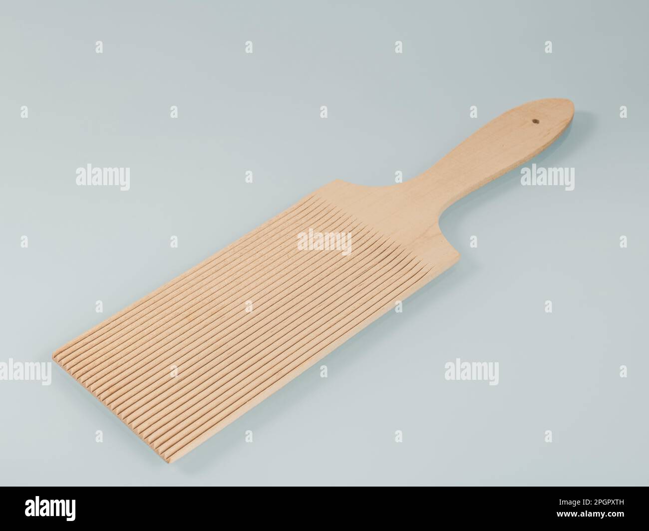 Wooden kitchen utensils. Wooden spatula with parallel grooves for ...