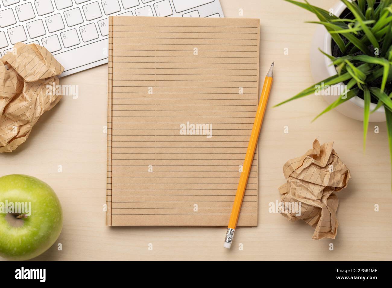 Top view of blank notepad, keyboard, eyeglasses and crumpled papers on ...
