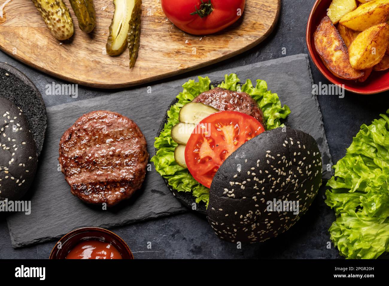 Homemade beef burgers with black buns and french fries. Flat lay Stock ...