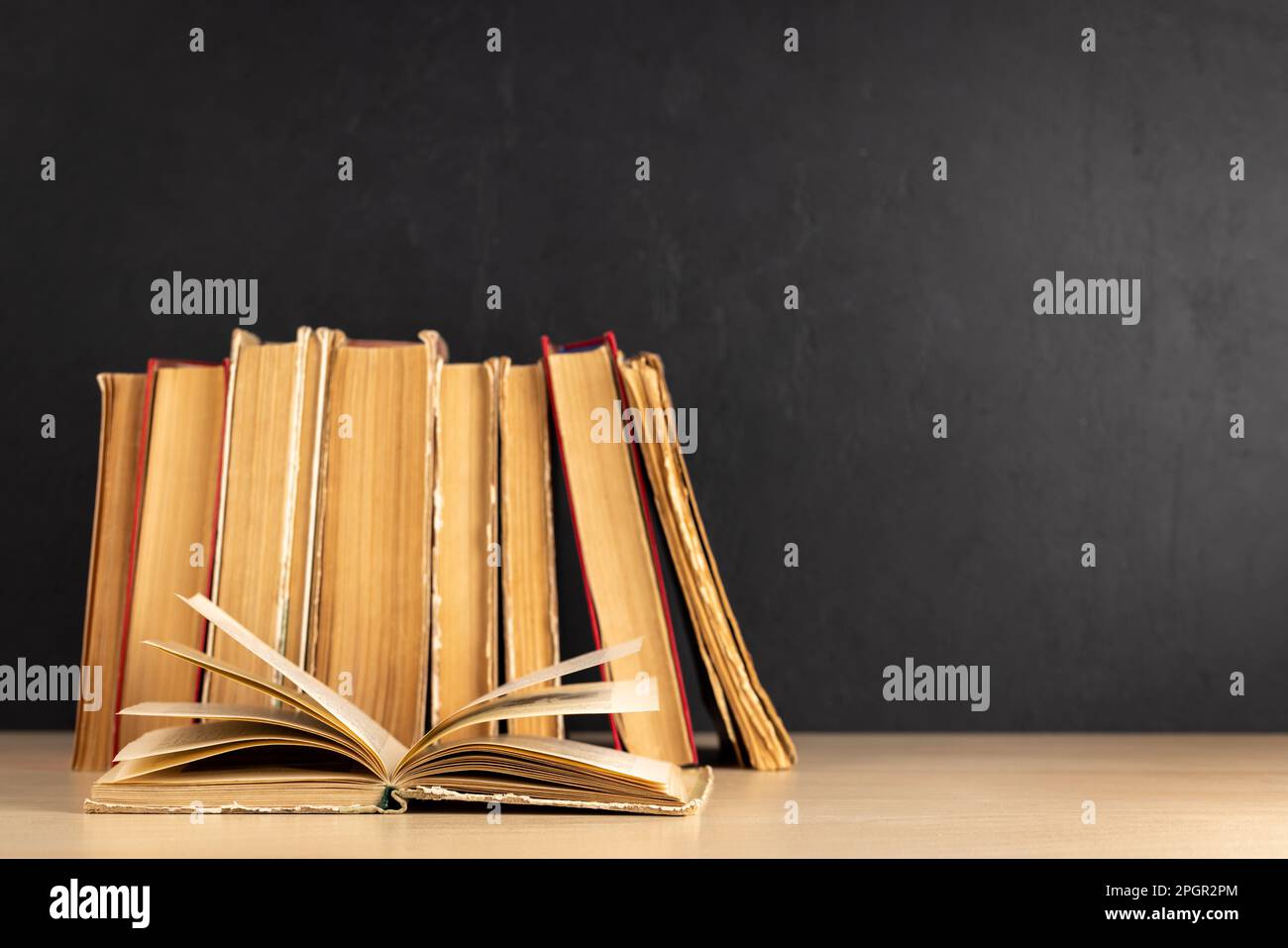 Old books on a table, with one book open and copy space for your text ...