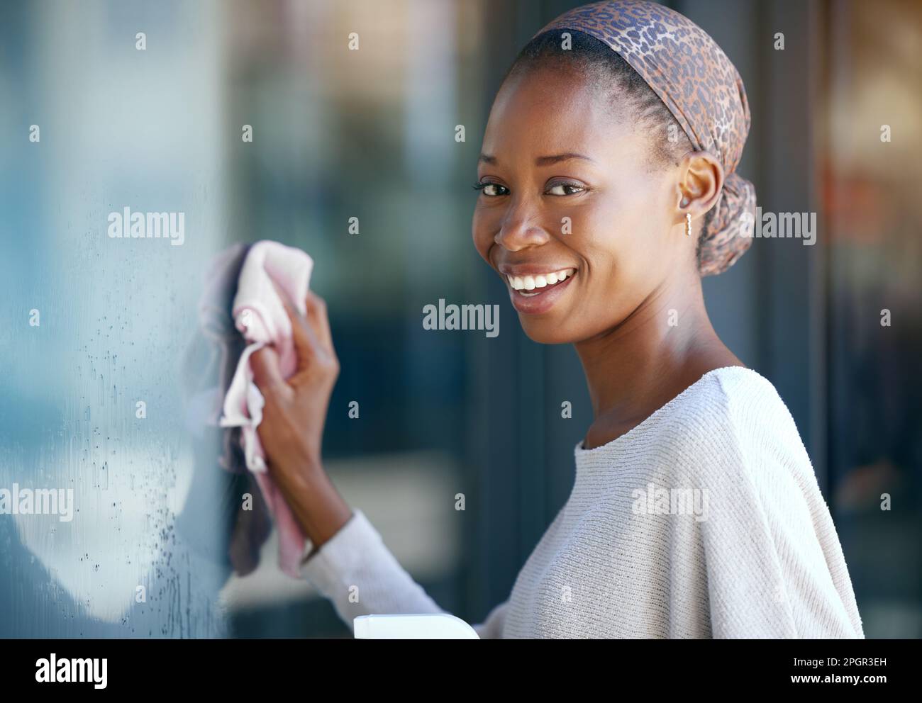Maid, housekeeper and black woman cleaning and wipe a glass window for ...
