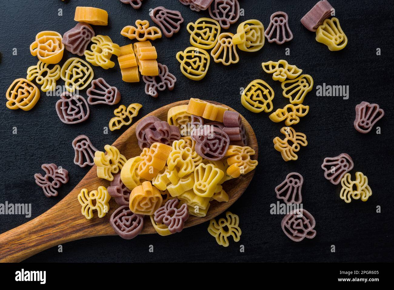 Pasta of various scary shapes. Uncooked halloween pasta in spoon on a ...
