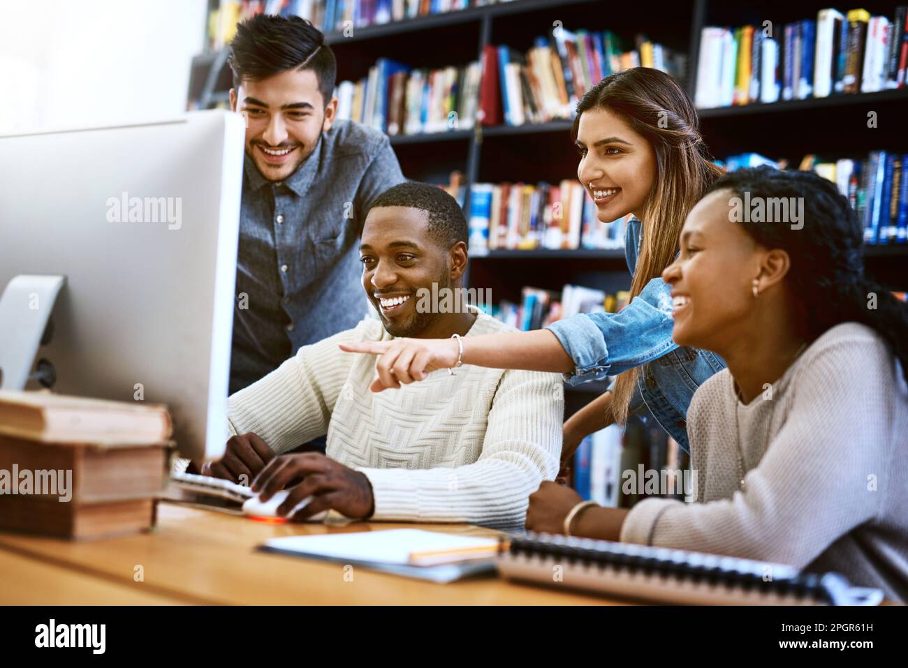 Education in action. a group of young students using a computer ...