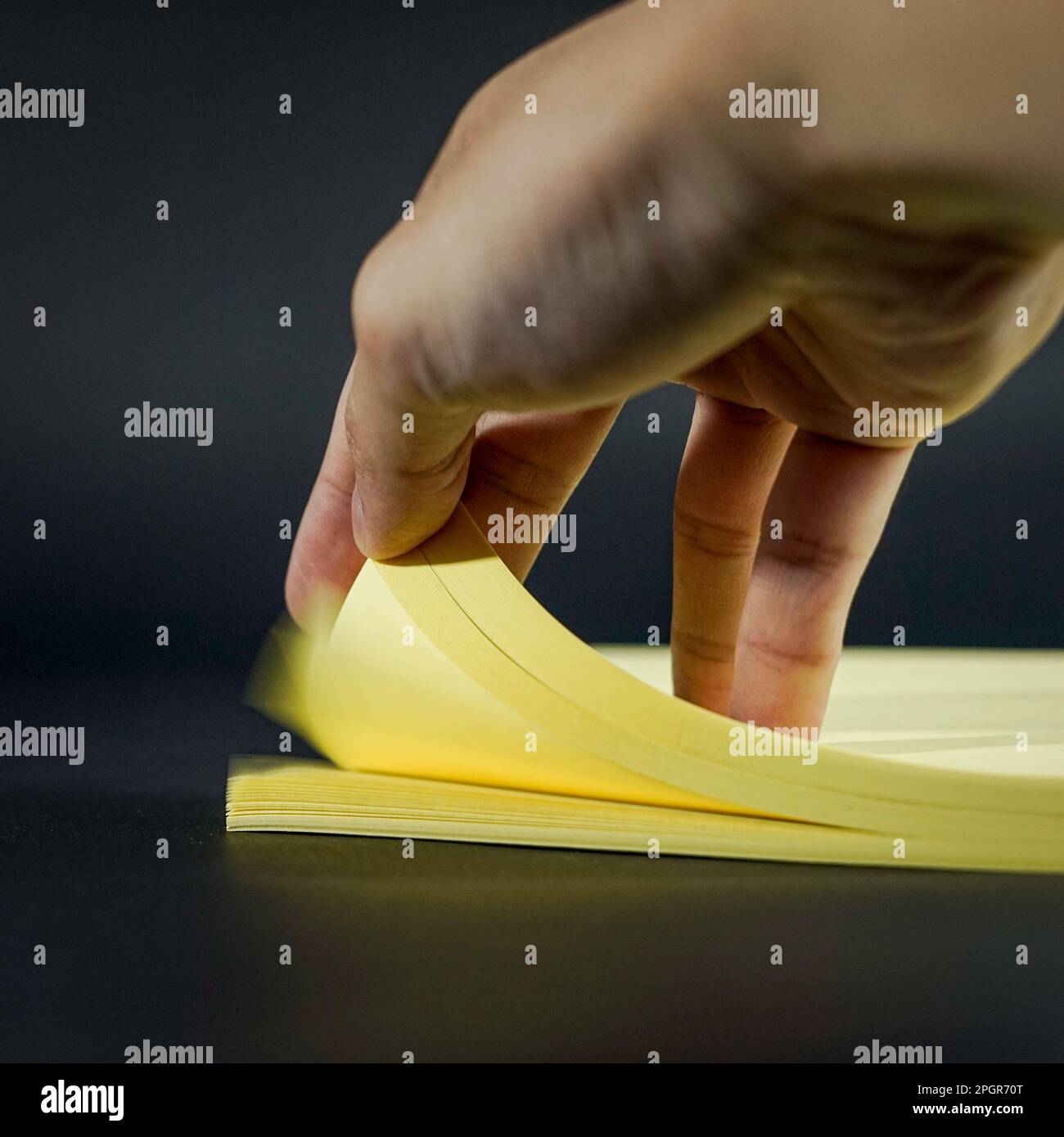 Stack of yellow colored paper with hand on frame Stock Photo - Alamy