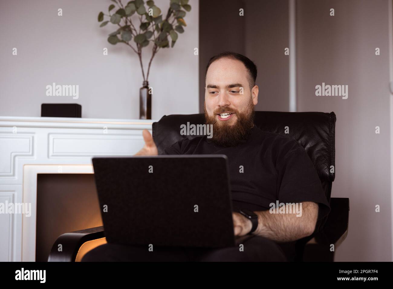 Man works from the comfort of his own home holding his laptop. Face ...