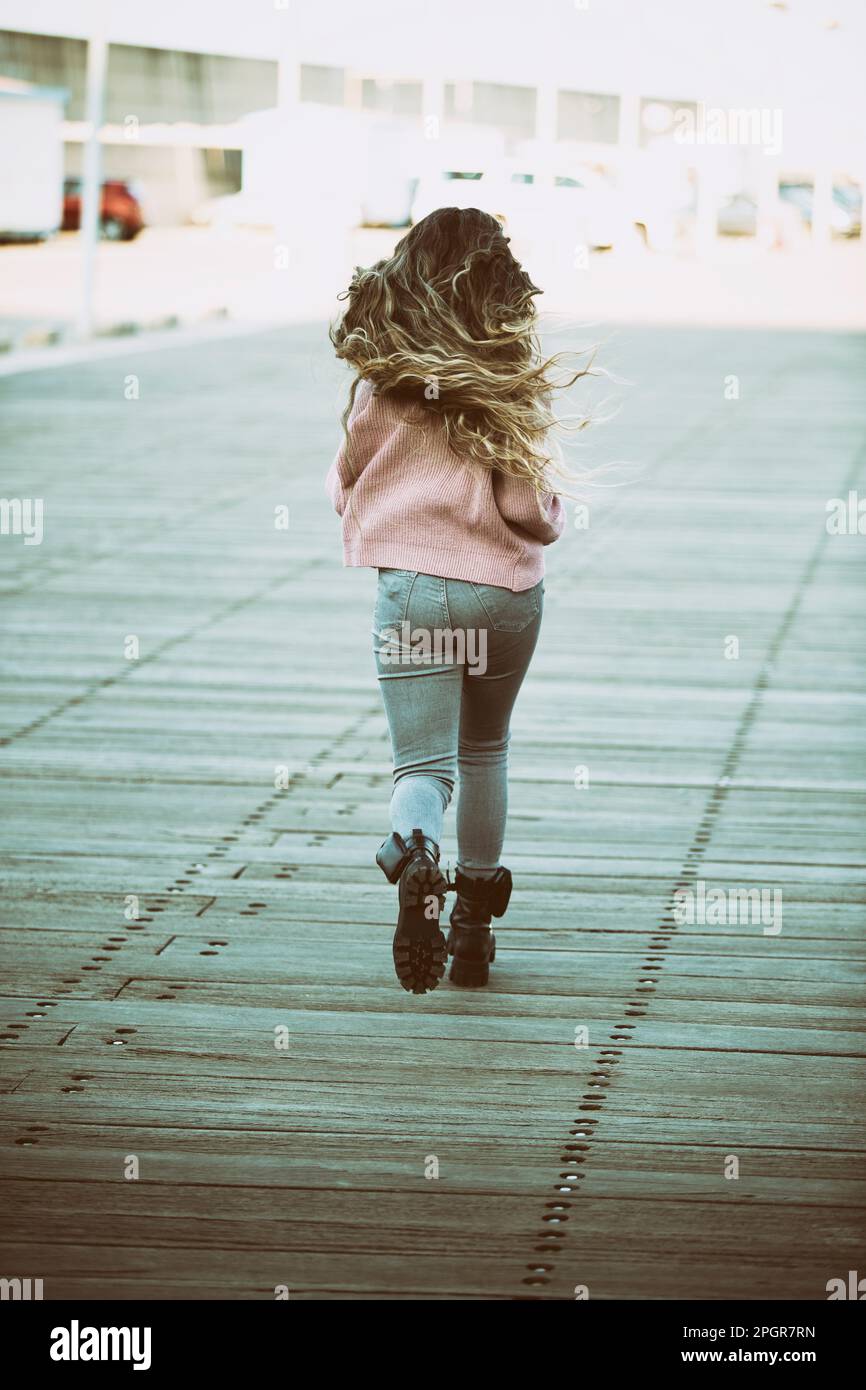 Girl running away outdoors Stock Photo - Alamy