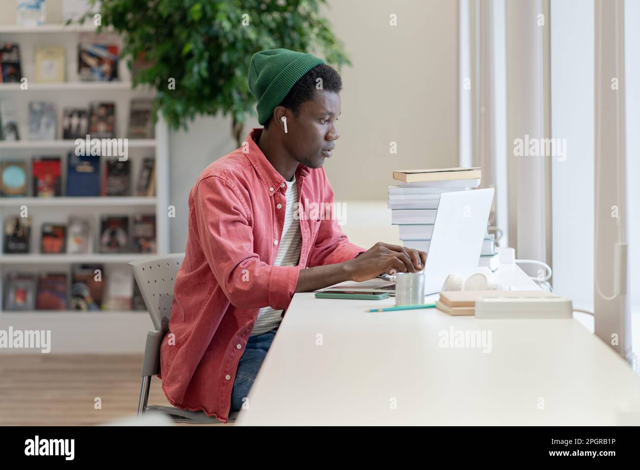 Focused young African man tutor teacher looking at laptop preparing for ...