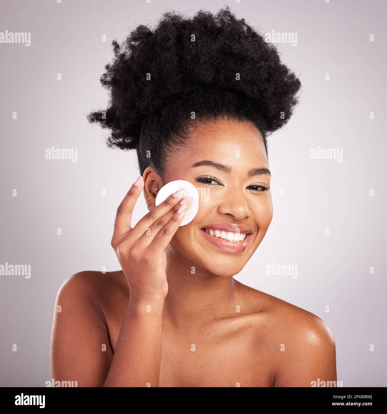 Black woman, cotton pad and skincare in studio with cleaning, makeup ...