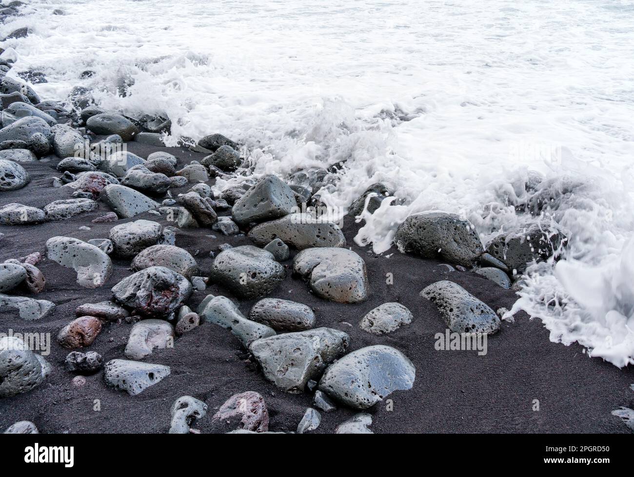 Close-up view of polished volcanic rocks on the Hawaiian coast being ...