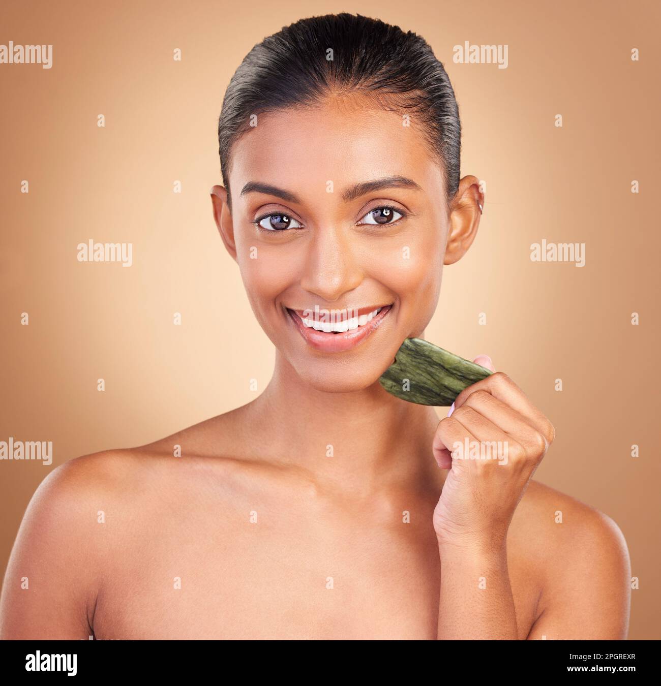 Beauty, gua sha and portrait of Indian woman with smile for skincare, facial treatment and spa ...