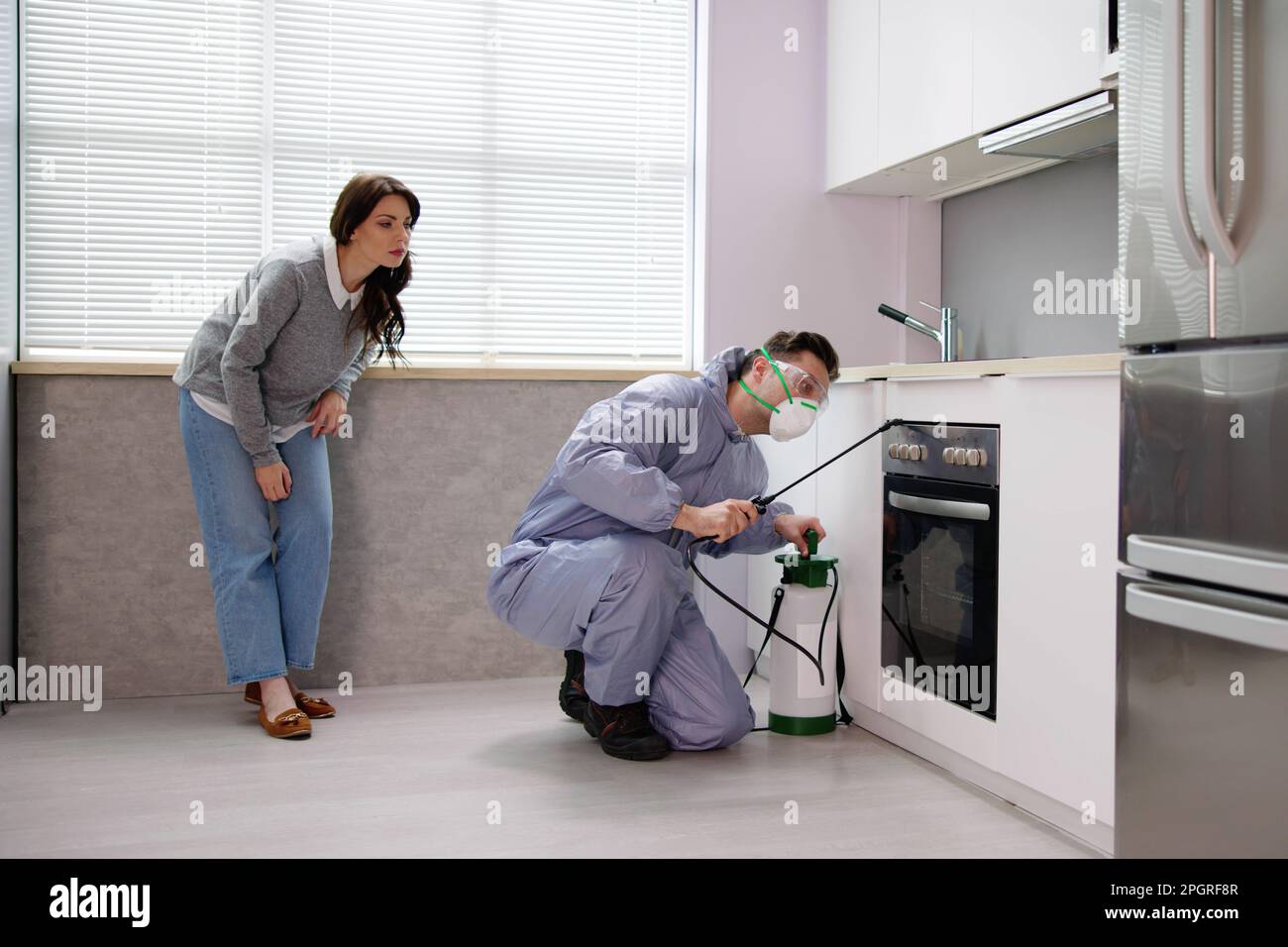 Woman Looking At Exterminator Worker Spraying Insecticide Chemical For ...