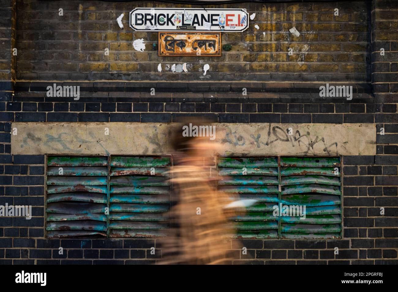 Blur of person walking past Brick Lane sign in London Stock Photo - Alamy