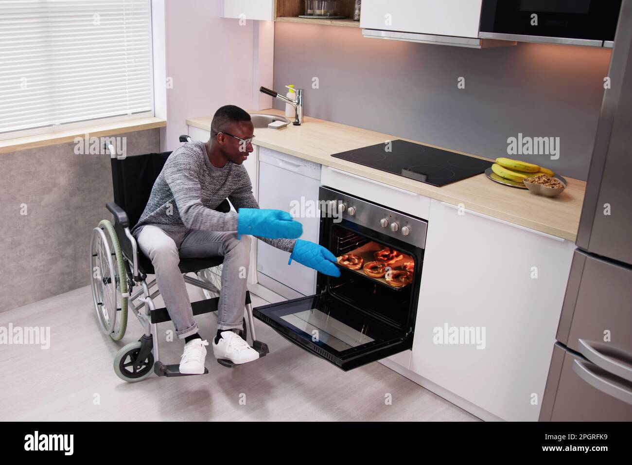 Disabled Man Using Microwave Oven For Baking In Kitchen Stock Photo - Alamy