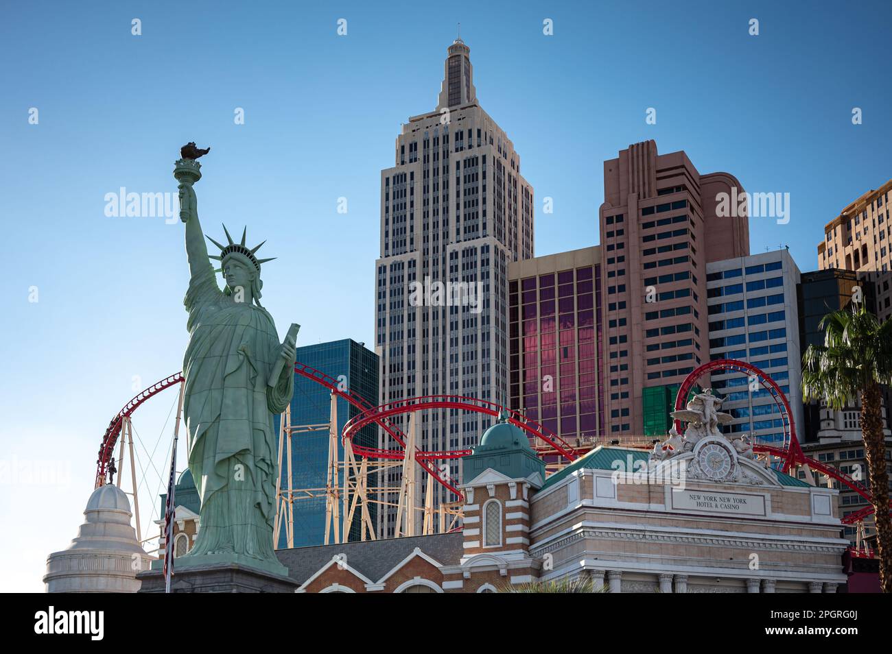 An amusement park with the iconic Statue of Liberty in the background ...