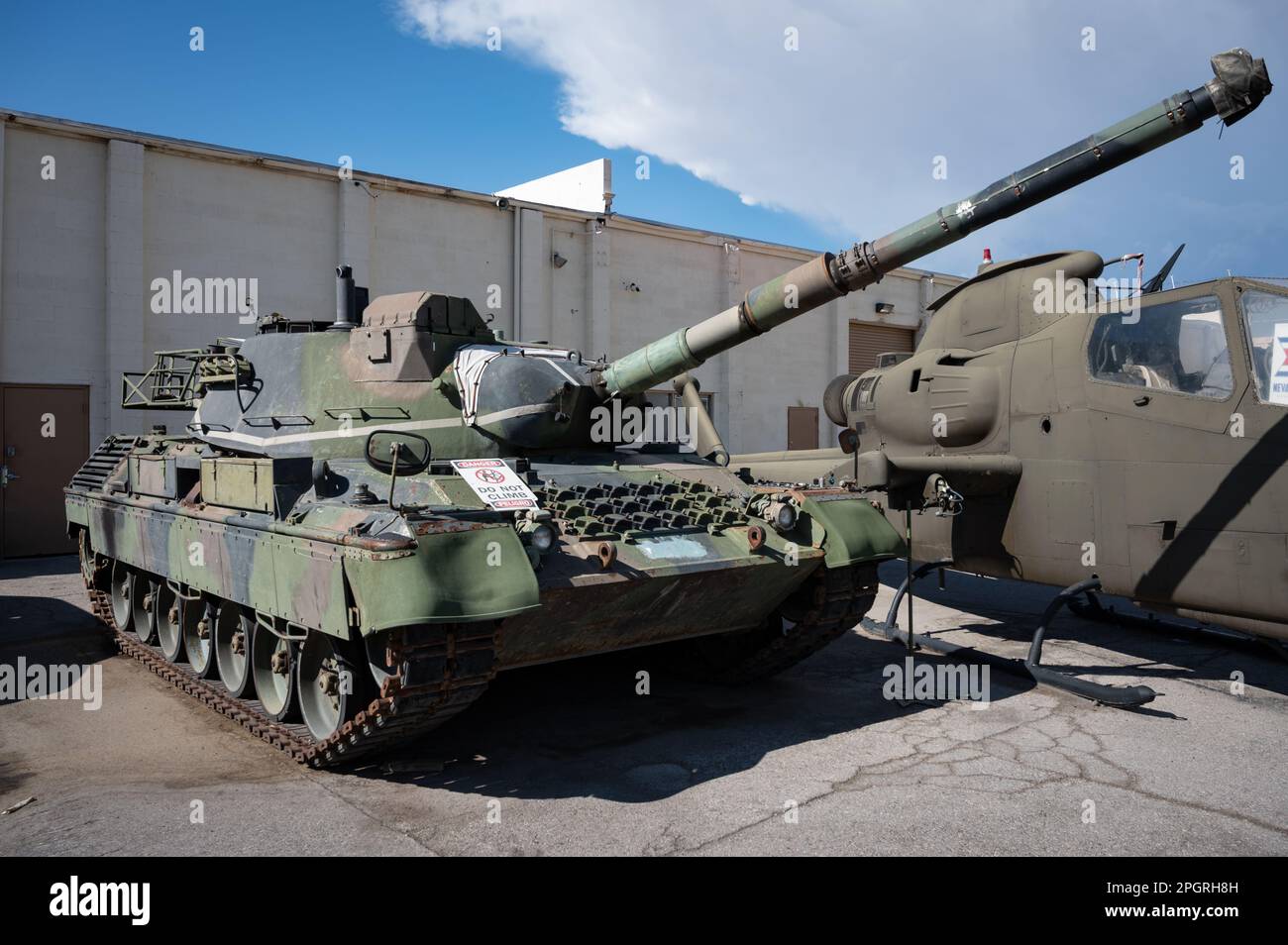 one large military tank and a helicopter situated in a warehouse Stock ...