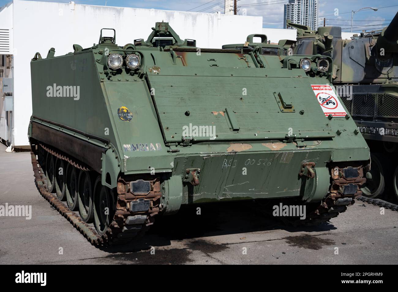 a large army tank sits on a truck in a warehouse lot Stock Photo - Alamy