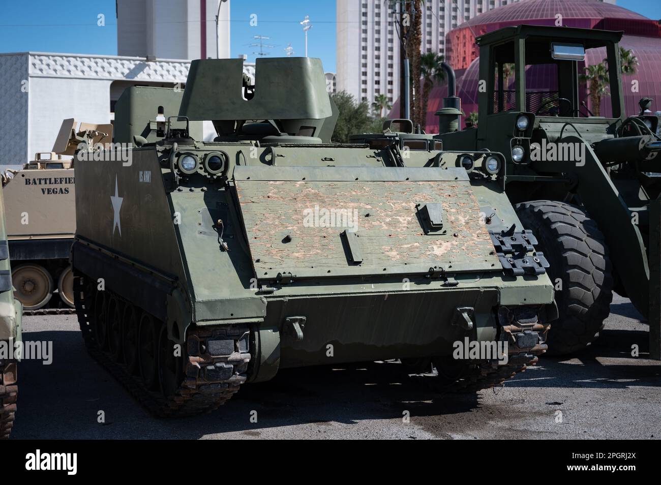 An olive green armored military vehicle is stationed in a large ...