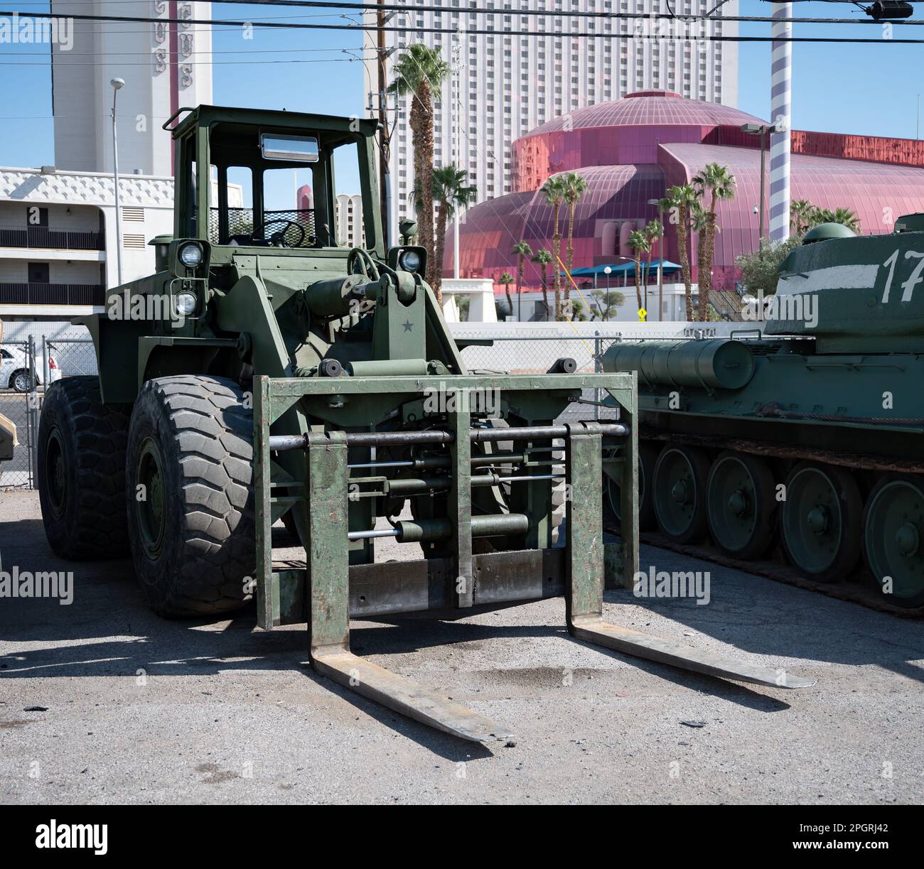 A green military forklift is seen in an outdoor warehouse, parked ...